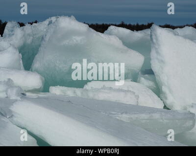 Thick slabs of frozen ice broken and piled on shore in winter Stock ...