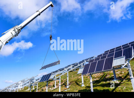 Mobile crane lifts a solar cell onto the mounting system solar ...