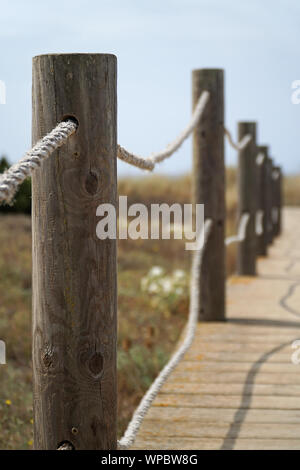 A wooden walkway to the beach with the blue water of the sea in ...