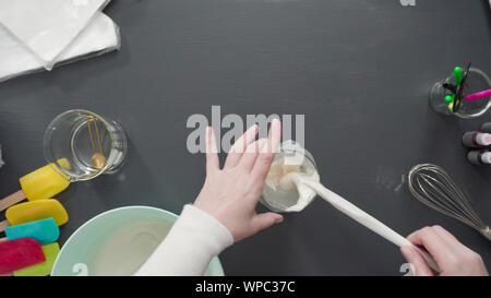 Step by step. Flat lay. Pouring royal icing into the piping bag to ...