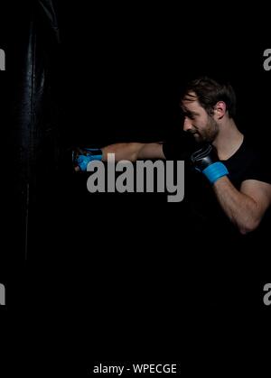 Boxing gloves in a low light room with black background Stock Photo - Alamy