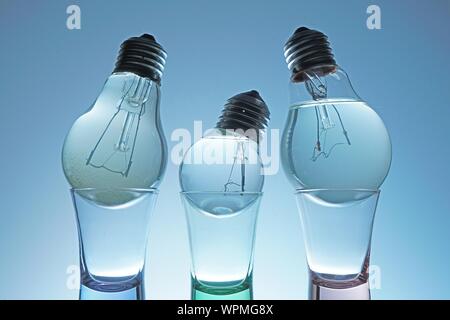 Glass light bulb filled with water and floating clock Stock Photo - Alamy
