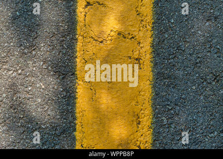 The yellow median strip separating the road surrounded by a dense green ...