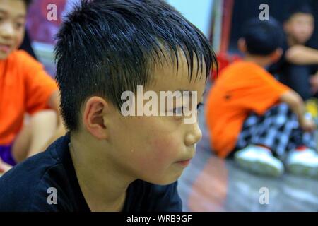 A young Chinese student sweats all over as he and others practise ...