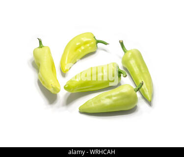 Three colorful paprikas on yellow background - Minimal flat lay view ...