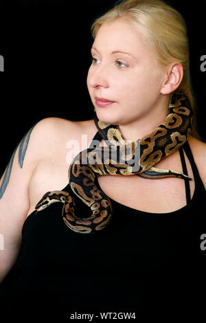 Woman with snakes around neck in dark tented alley Stock Photo - Alamy
