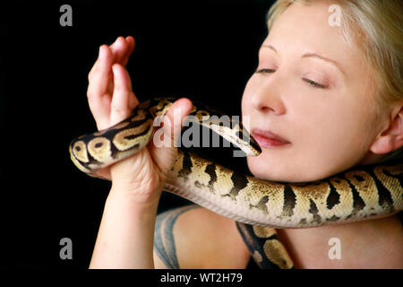 Woman with snakes around neck in tented dark alley Stock Photo - Alamy