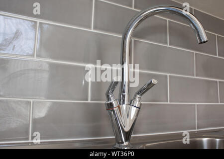 Typical kitchen sink taps with grey tiles Stock Photo - Alamy