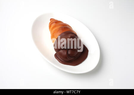 chocolate cornet roll bread on plate closeup isolated on white ...
