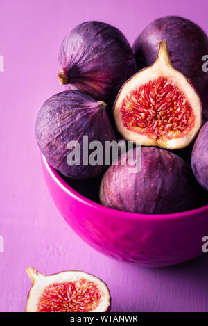 Fresh figs in a pink bowl on a white wooden background, side view ...