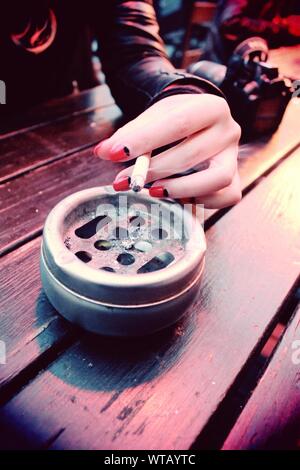 Woman smoking cigarette with ashtray at table in pub Stock Photo - Alamy