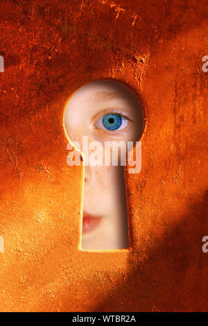 a human eye peering through a keyhole Stock Photo - Alamy
