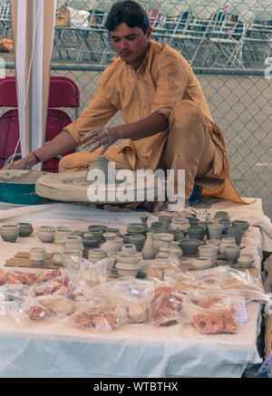 Traditional indian man pottery maker building clay pot while his wife ...