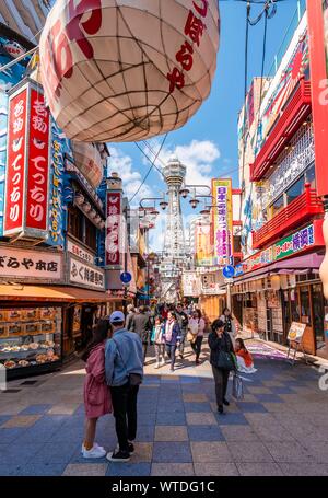 Tsutenkaku Tower in Shinsekai district, Osaka, with bustling street ...