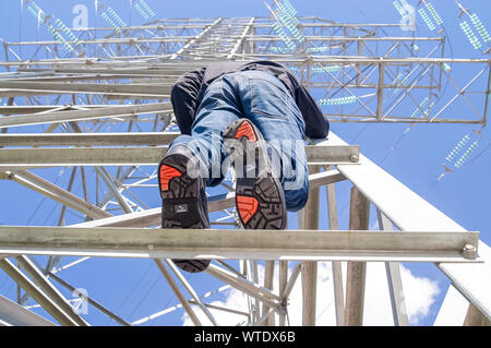 Cable lineman climbing a ladder to repair transmission line Stock Photo ...