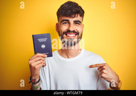 Young man with tattoo wearing German Germany passport over isolated ...