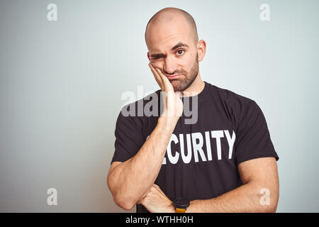Young safeguard man wearing security uniform over yellow isolated ...