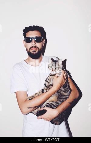 Young man carrying cat, portrait Stock Photo - Alamy