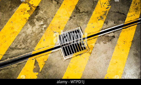 Yellow striped road markings on black asphalt highway. No parking is ...