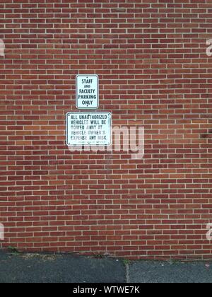 The front view of a brick building with signs, pavement and wooden ...