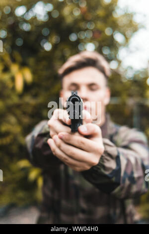 Man shooting with a gun Stock Photo - Alamy