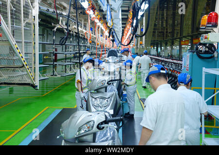Chinese factory workers assemble motorcycles on the assembly line at ...