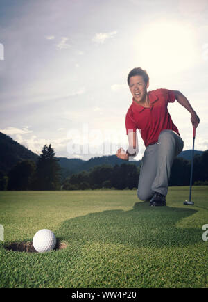 Golfer with arms raised while shouting Stock Photo - Alamy
