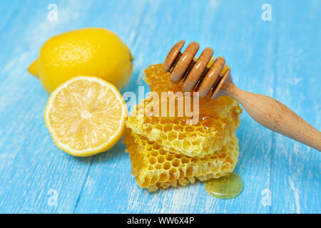 Honeycombs and lemon lie on a blue wooden background Stock Photo - Alamy