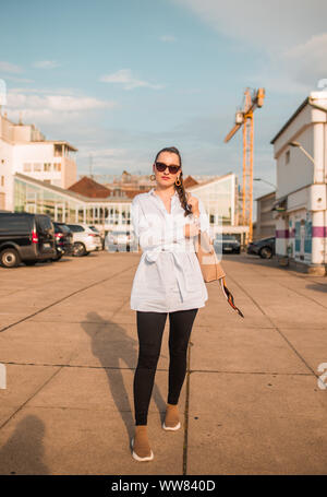 Beautiful woman in black t-shirt and red skirt and glasses walking in ...