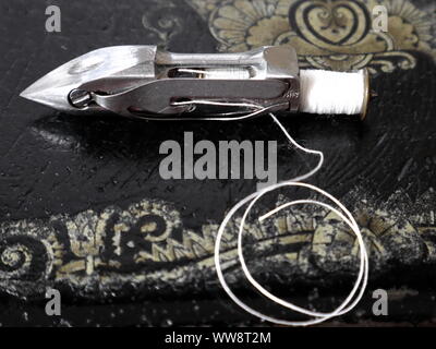 Close up of bobbin and shuttle from an antique sewing machine in ...