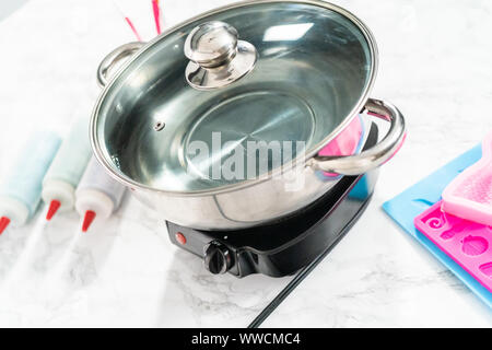 Melting chocolate melts in plastic bottles in hot water Stock Photo - Alamy