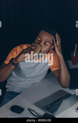 young african american programmer drinking coffee to go while working ...