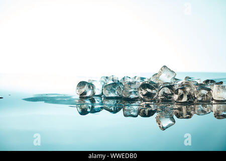 melting ice cubes on emerald and white background Stock Photo - Alamy