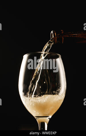 beer flowing from bottle into glass isolated on black Stock Photo - Alamy