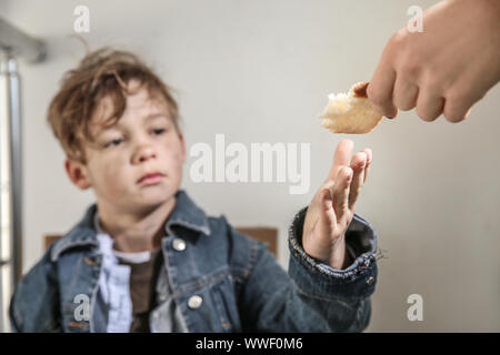 Woman giving food to homeless little boy outdoors Stock Photo - Alamy