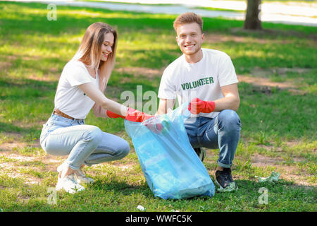 Volunteers gathering garbage in park Stock Photo - Alamy