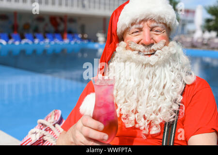 Santa Claus with cocktail near swimming pool at resort Stock Photo - Alamy