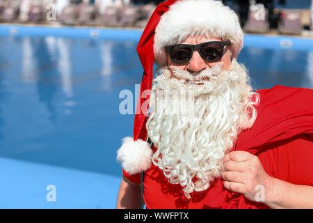 Cool Santa Claus near swimming pool at resort Stock Photo - Alamy