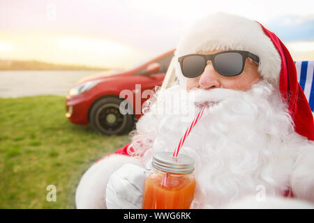 Cool Santa Claus with cocktail resting on riverside Stock Photo - Alamy
