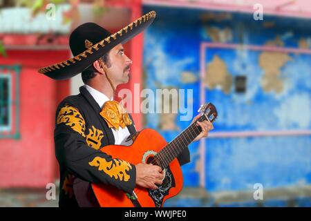 Charro Mariachi singer playing guitar in Mexico with white house ...