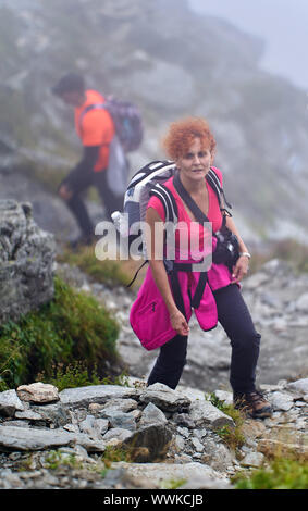 Backpacker lady with camera hiking on a mountain trail Stock Photo - Alamy