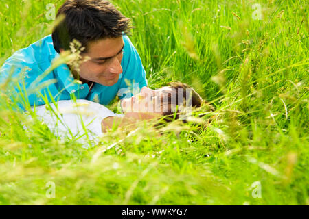 Happy couple laying down meadow Stock Photo - Alamy