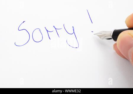 Say sorry with a text message on paper and pen Stock Photo - Alamy