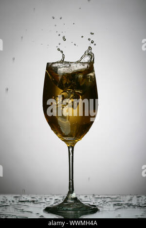 alcohol splash on gray background Stock Photo - Alamy