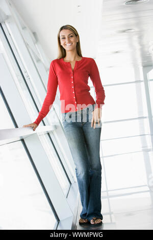 Woman in early twenties standing in bright modern office holding ...