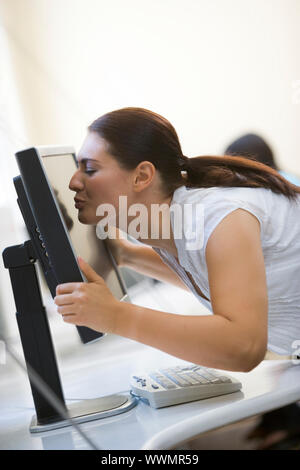 Woman in computer room kissing monitor Stock Photo - Alamy