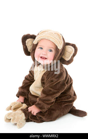 Vertical shot of an adorable monkey sitting on a stone with closed eyes ...