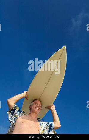 Middle-Aged Surfer Carrying Surfboard Stock Photo - Alamy