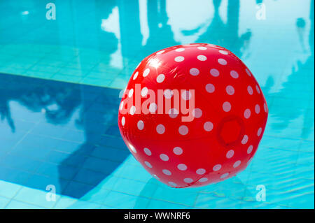 Red spotted beach ball floating in the outdoor swimming pool Stock ...