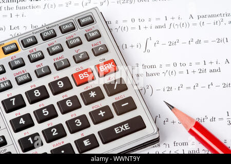 Scientific calculator and a red pencil on top of a sheet of paper with ...